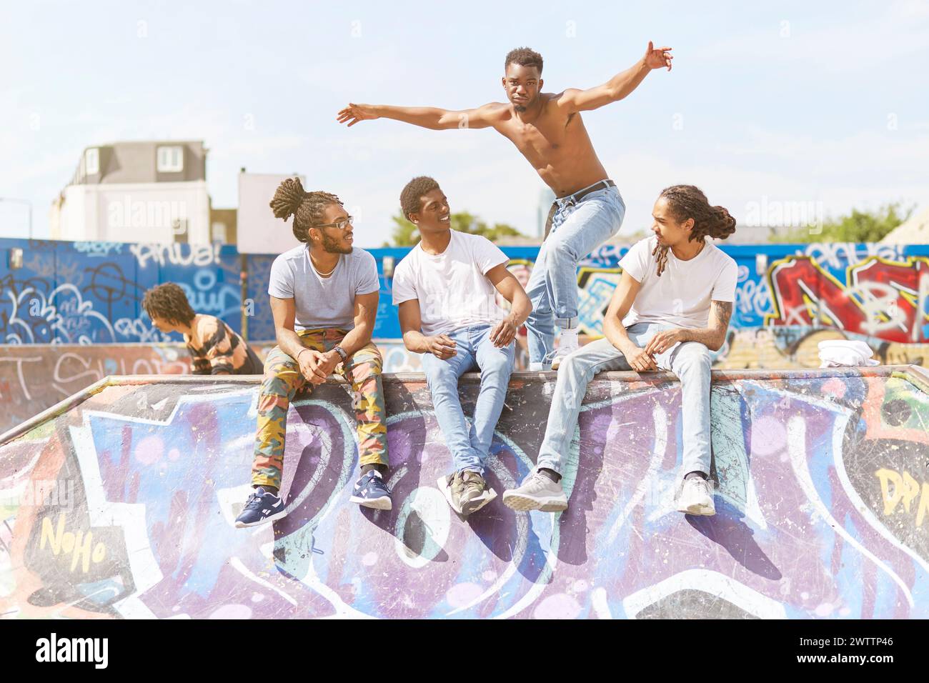 Friends enjoying time at a graffiti-covered skatepark Stock Photo - Alamy