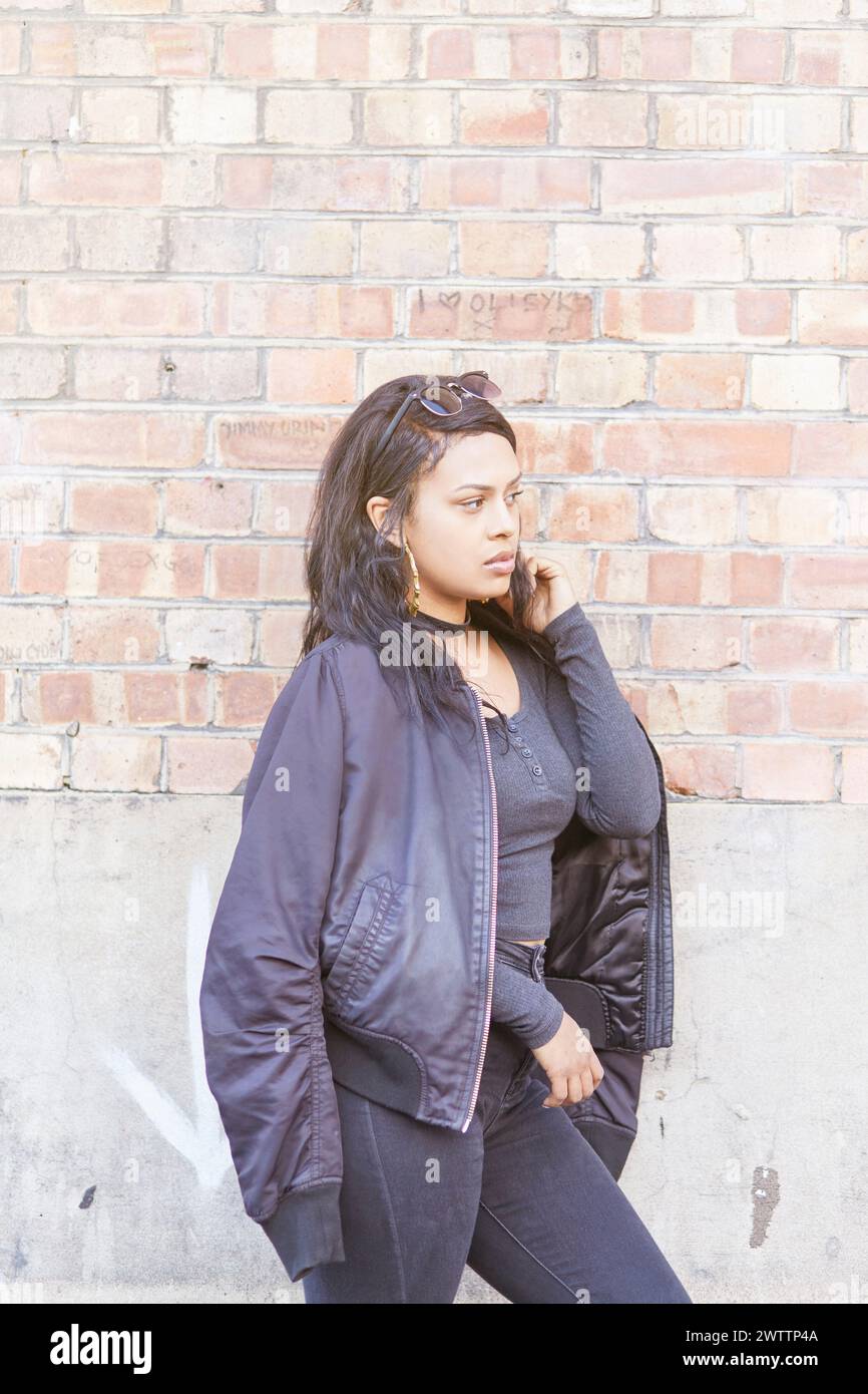 Woman standing against brick wall hi-res stock photography and images ...
