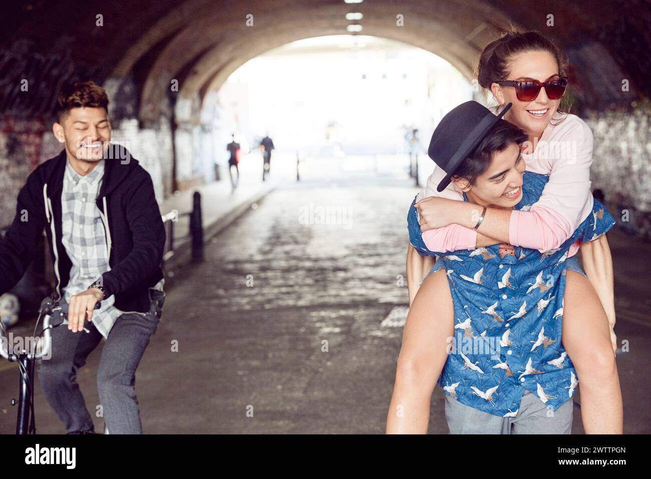 Friends enjoying a piggyback ride in a tunnel Stock Photo - Alamy
