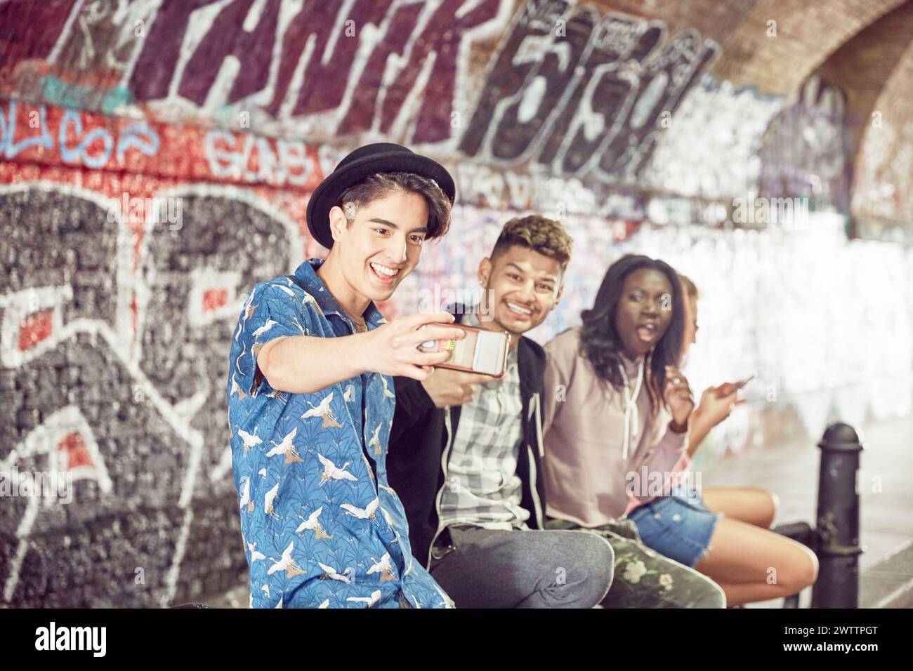 Friends taking a selfie in a graffiti-covered tunnel Stock Photo - Alamy