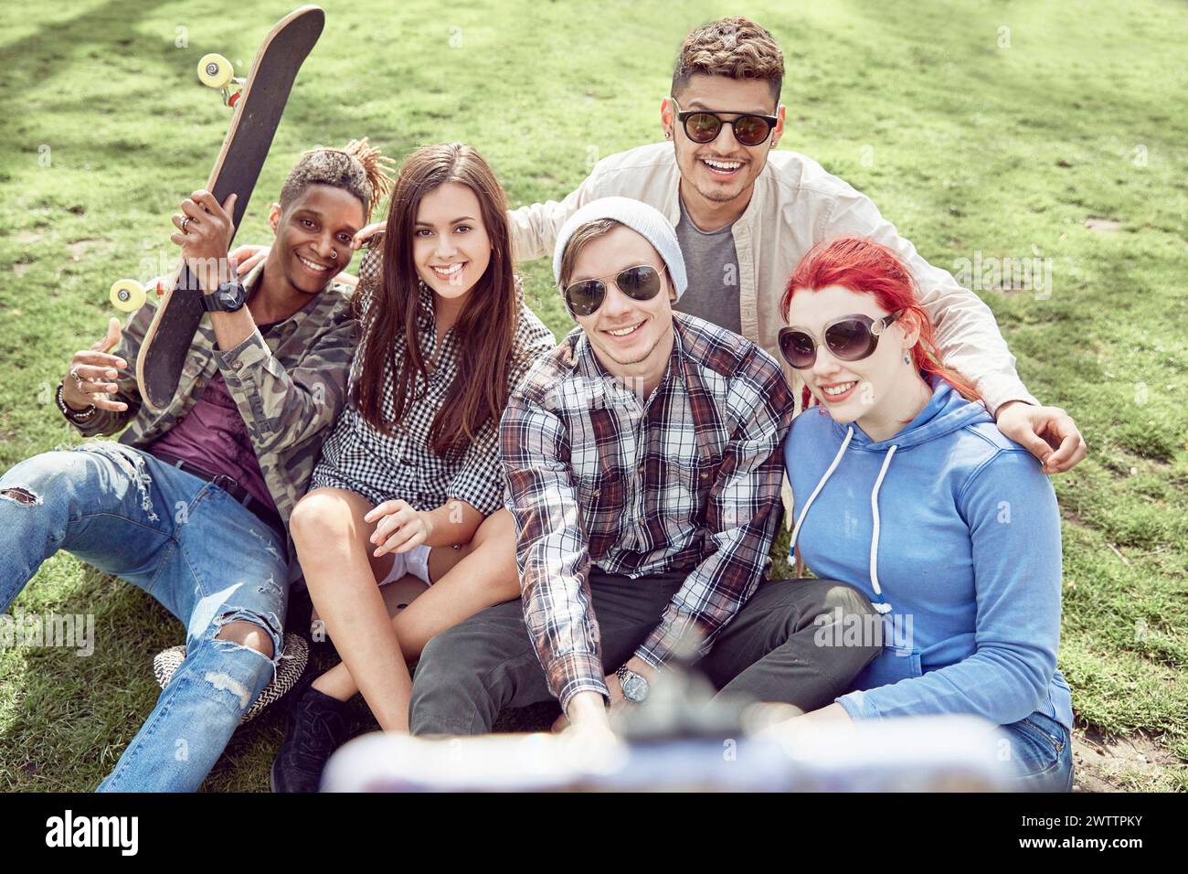 Group of friends smiling outdoors with a skateboard Stock Photo - Alamy