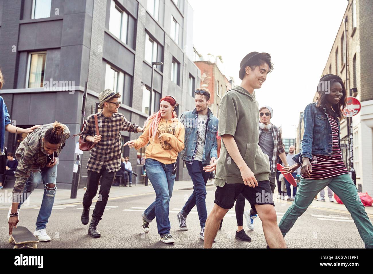 Group of friends walking down a city street Stock Photo - Alamy