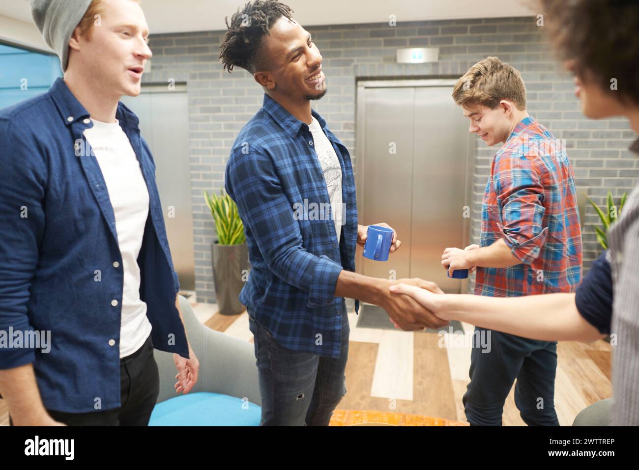 Men greeting each other in a modern office Stock Photo - Alamy