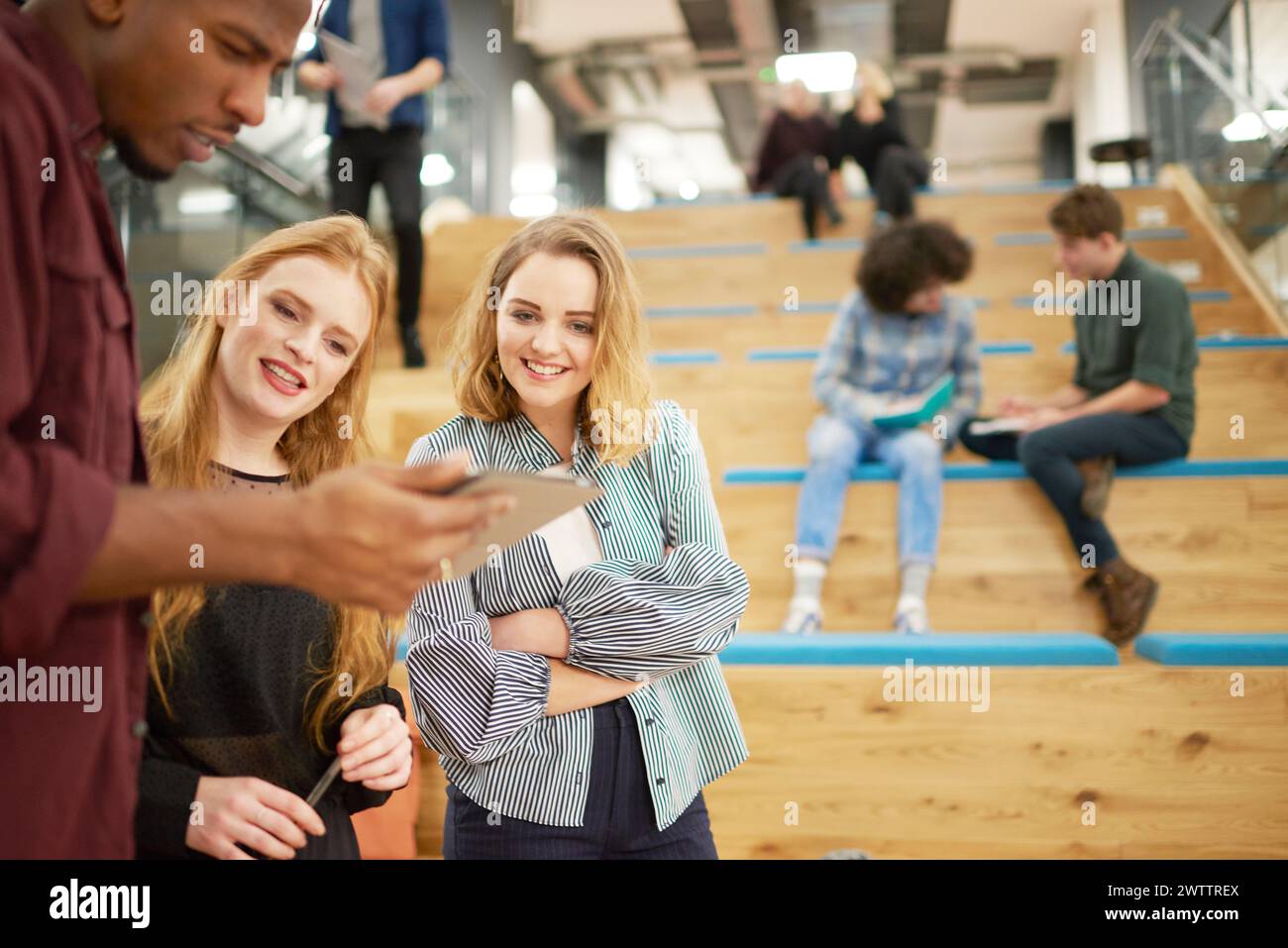 Group of people using a smartphone together on steps Stock Photo - Alamy
