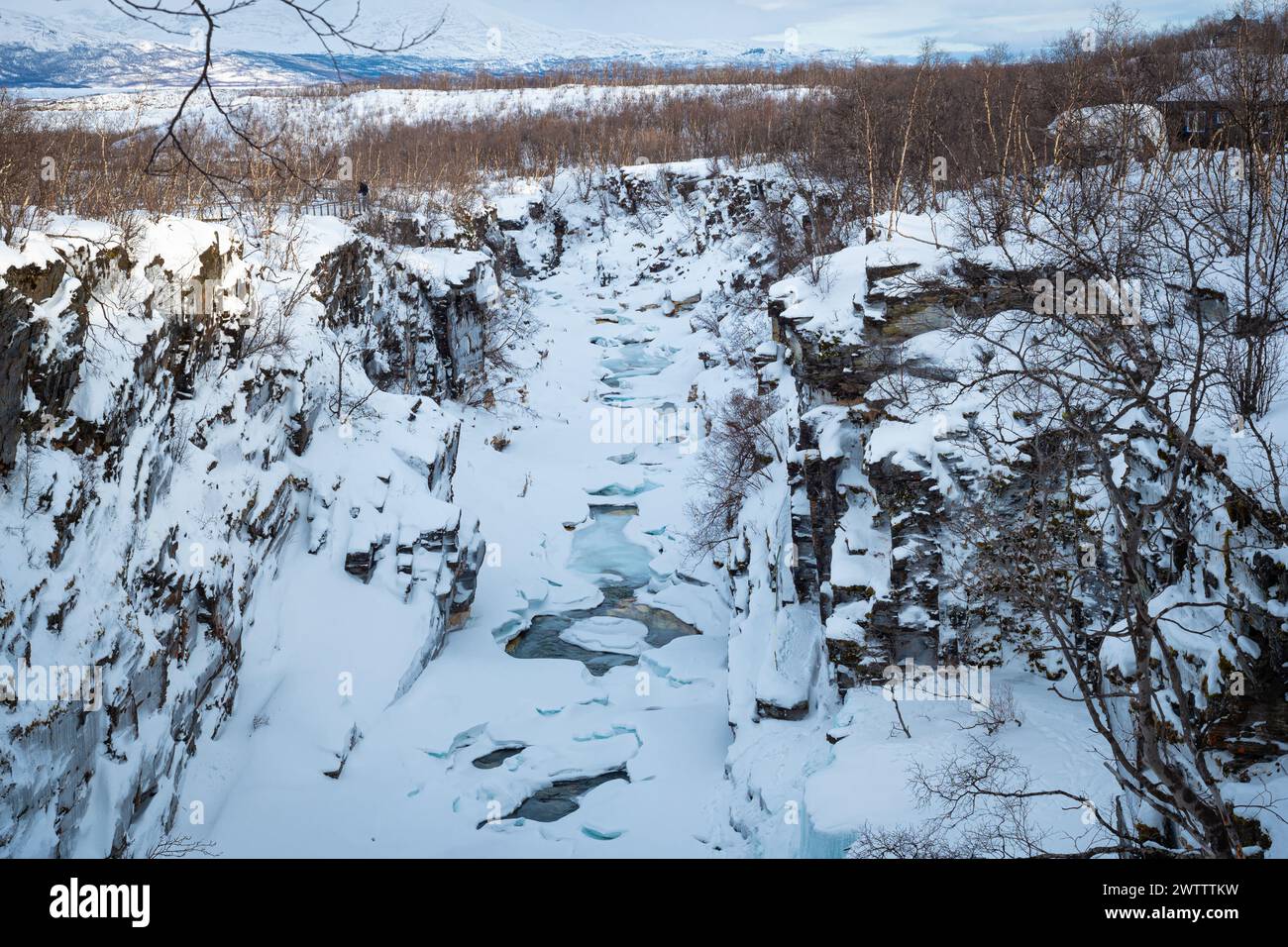 Arctic landscape of snow, ice, water and steep rock walls at the Abisko ...