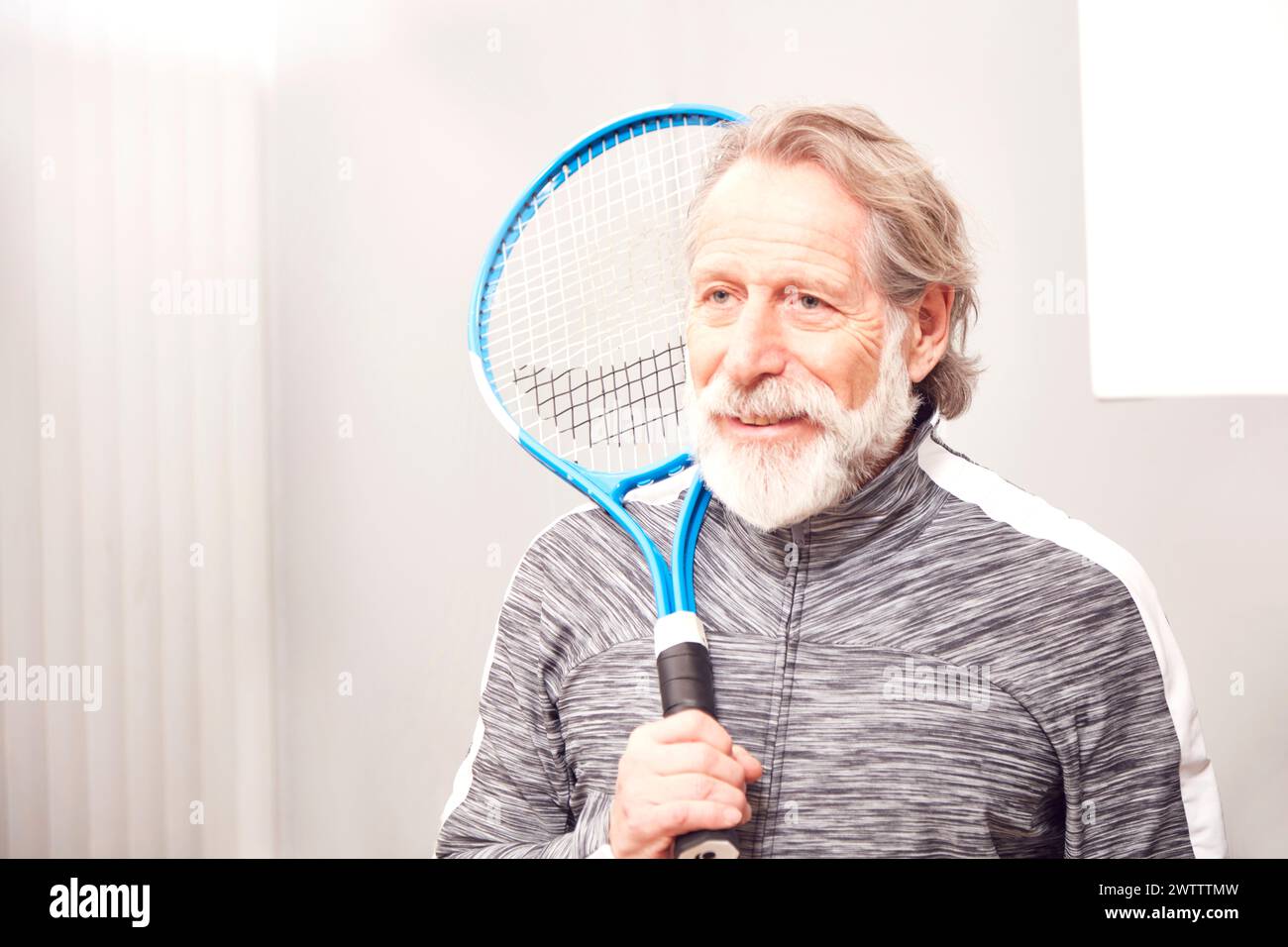 Elderly man holding a tennis racket Stock Photo - Alamy
