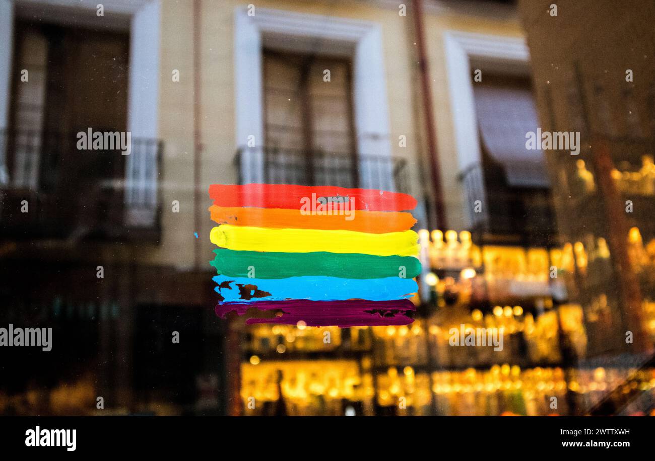 Rainbow flag drawn with different colors on a glass front door of a ...