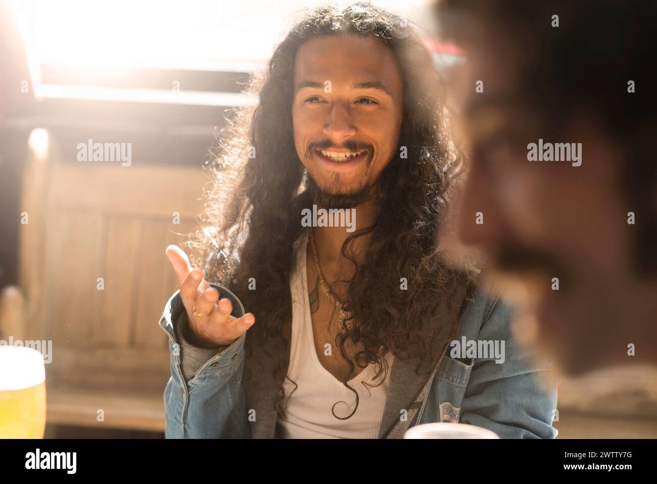 Man smiling and gesturing during a conversation Stock Photo - Alamy