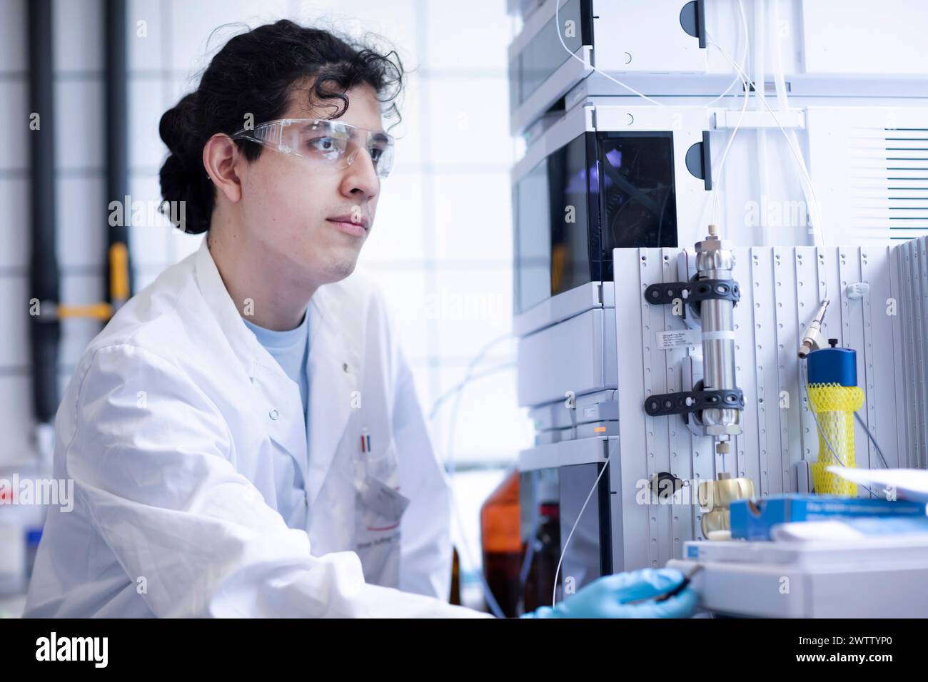 Focused scientist adjusting equipment in a modern lab Stock Photo - Alamy