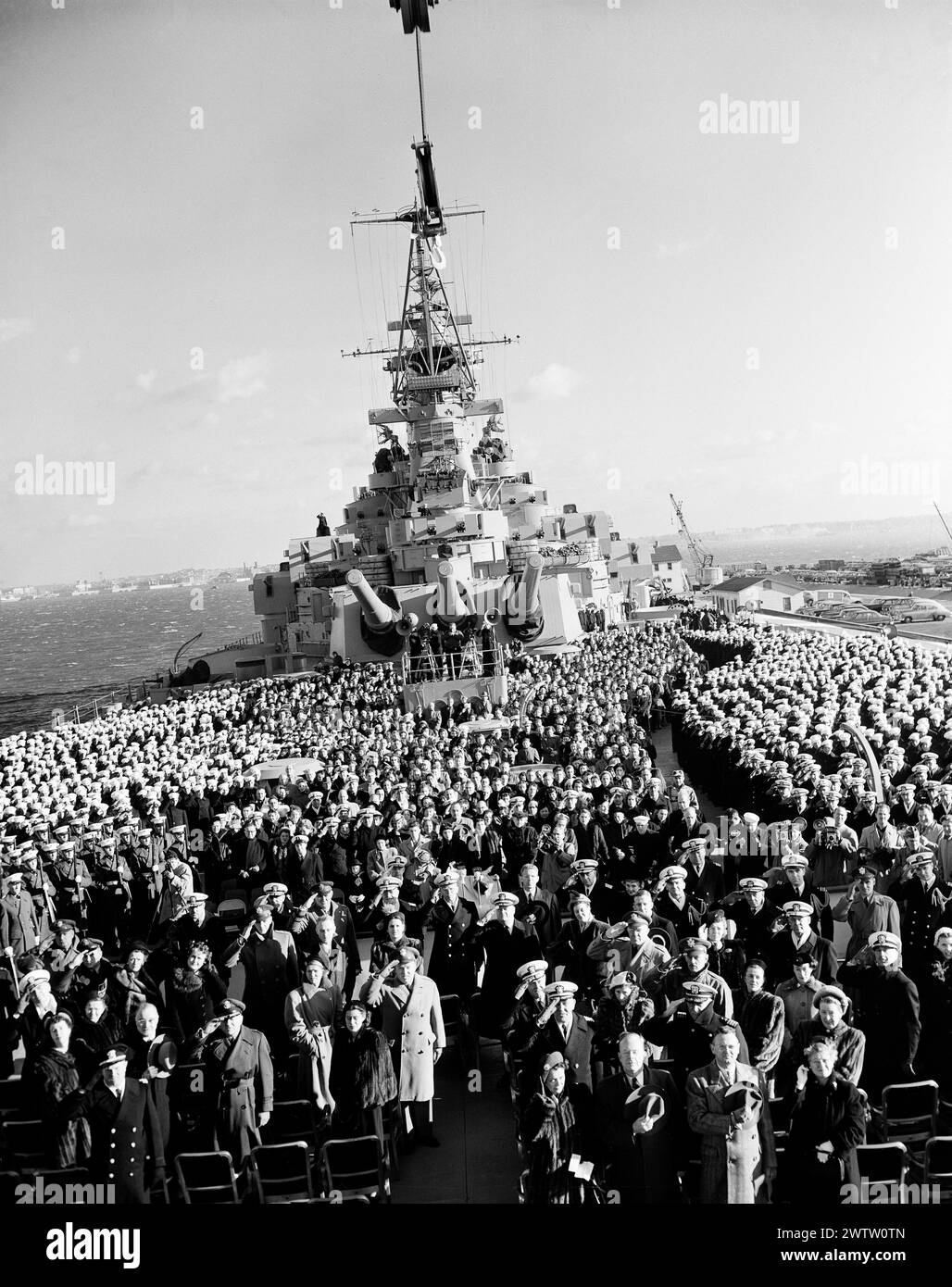 Officers and crew salute during hoisting of the colors at the ceremony ...