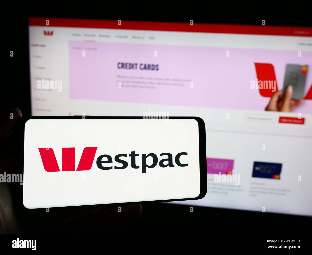 Person holding mobile phone with logo of Australian financial company ...