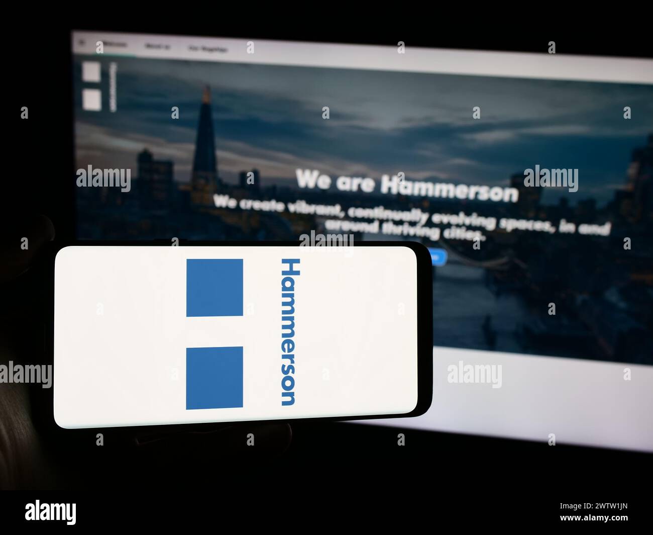 Person holding smartphone with logo of British property company ...