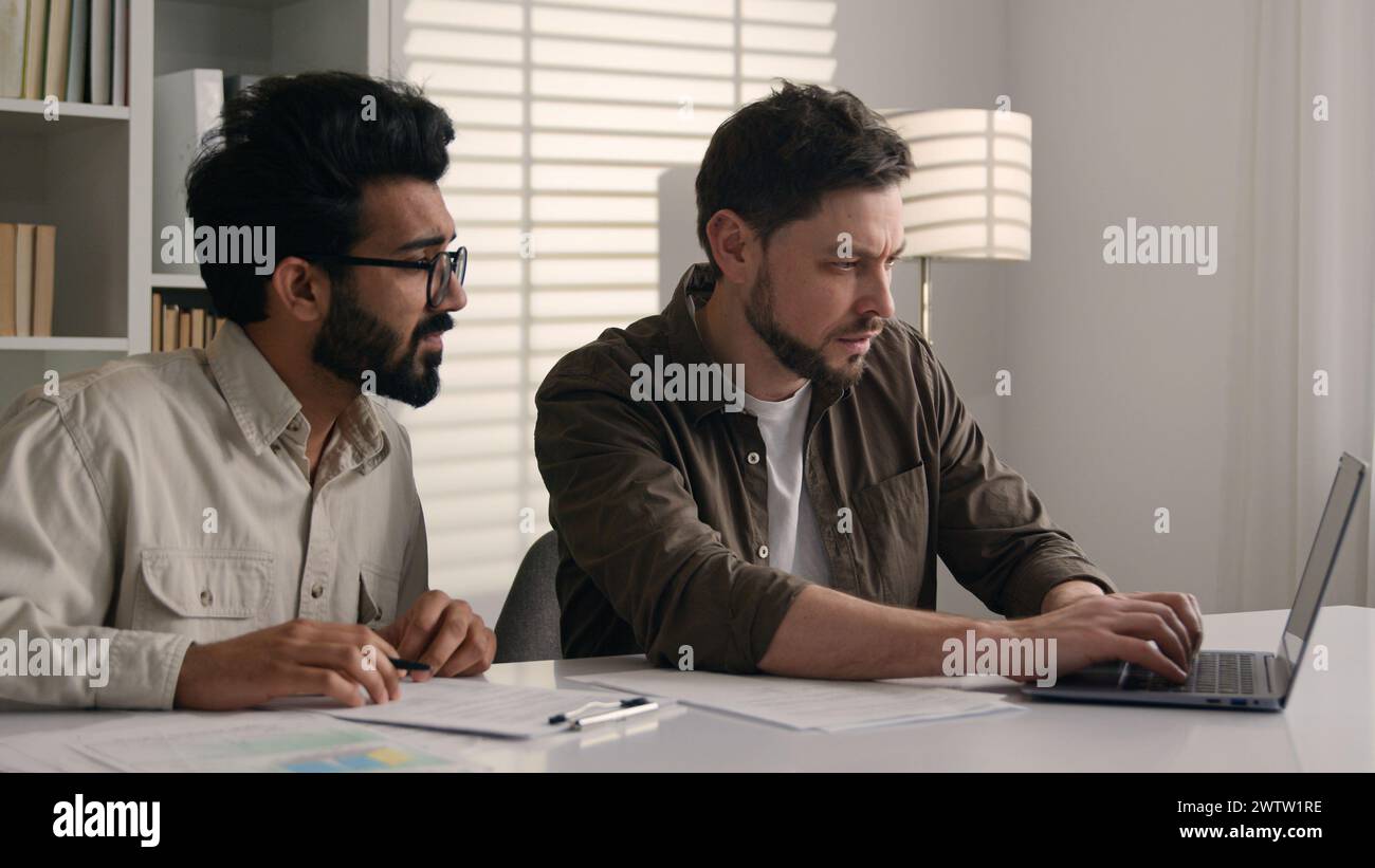 Two multiethnic colleagues businessmen business coworkers at office ...