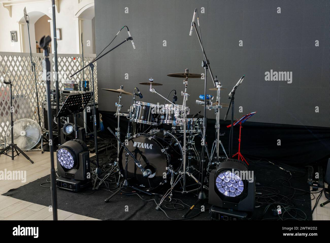 a Live music stage setup with drum set and professional lighting, ready ...