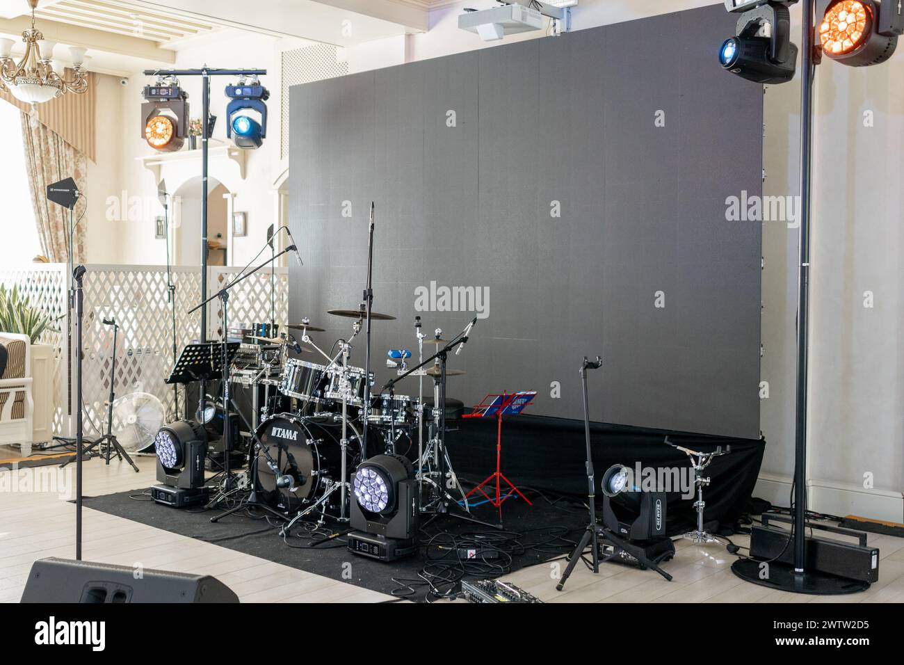 a Live music stage setup with drum set and professional lighting, ready ...