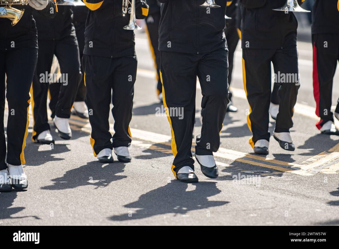 High school marching band, in red uniforms and spats, keeps cadence ...