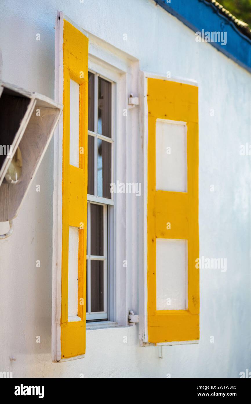 A sunny and warm house facade featuring bright yellow window shutters ...