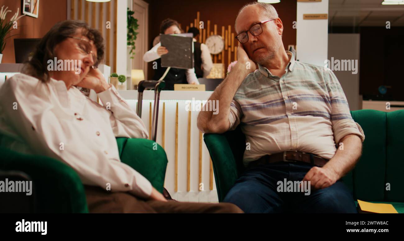 Sleepy elderly couple napping on sofa at hotel lobby, feeling exhausted ...