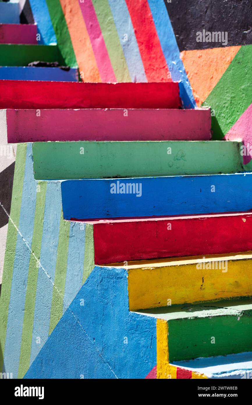 A view of a staircase with steps painted in bold colors and geometric ...