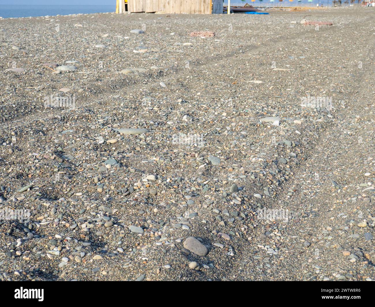 Rut in the sand. Tracks from car wheels on the beach. Sand and stones ...