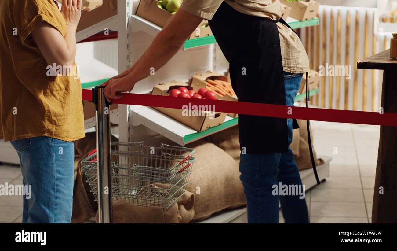 Vendor greeting first clients in newly opened zero waste supermarket ...