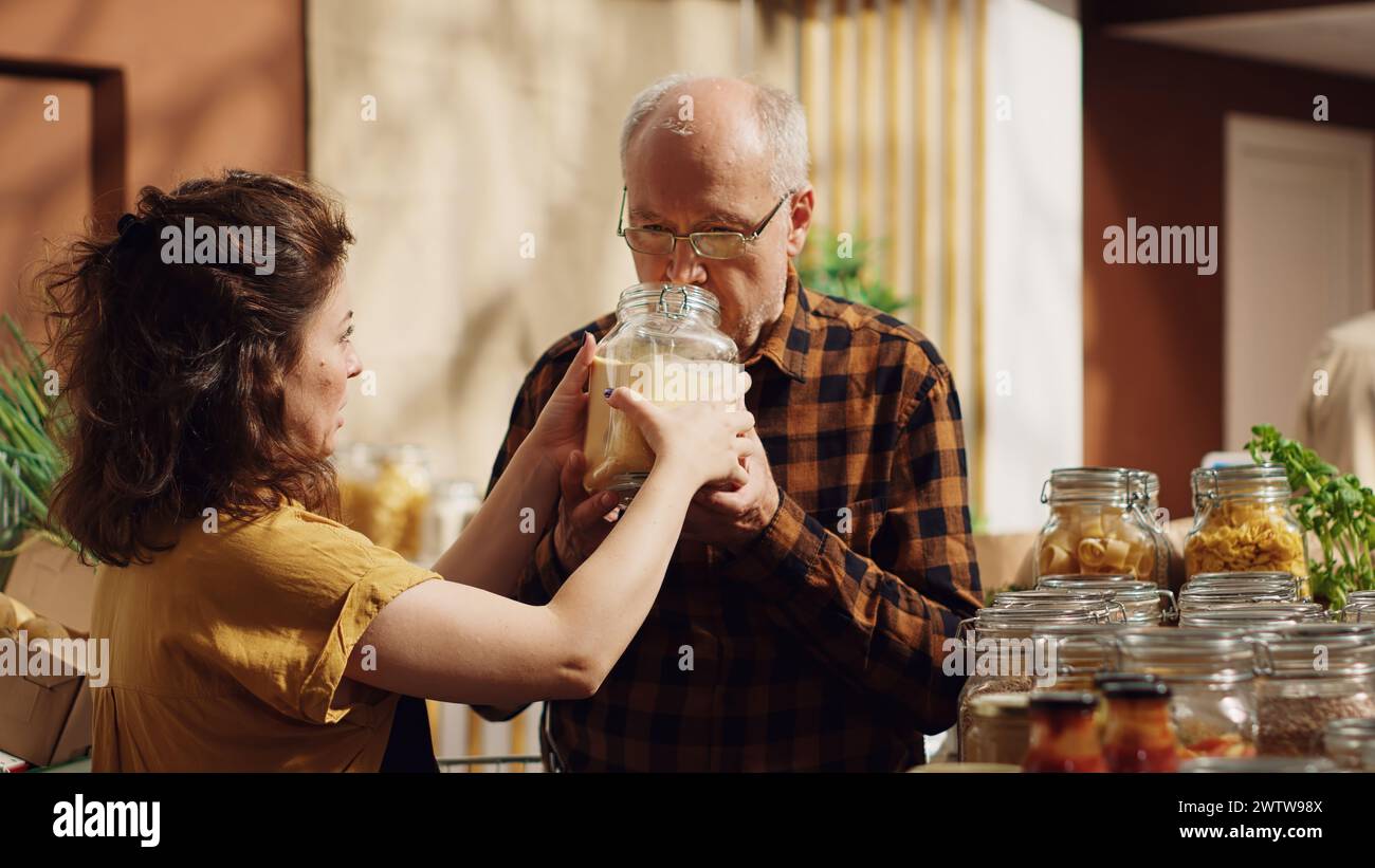Eco friendly zero waste supermarket vendor assisting elderly client ...