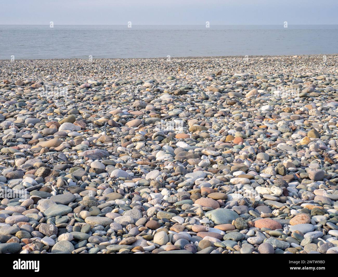 Gray sand and stones on the beach. Beach in winter. Sea coast soil ...