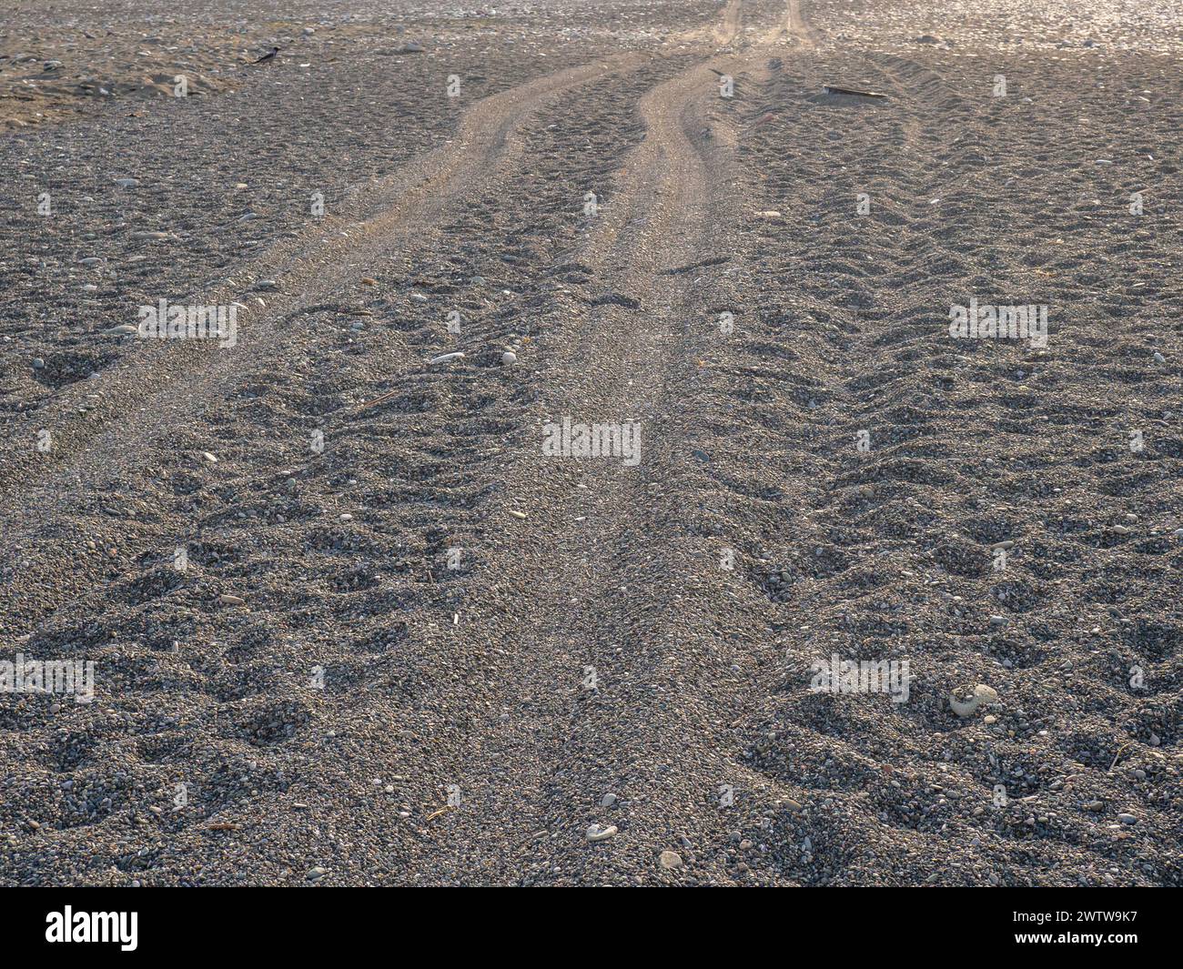 Rut in the sand. Tracks from car wheels on the beach. Sand and stones ...