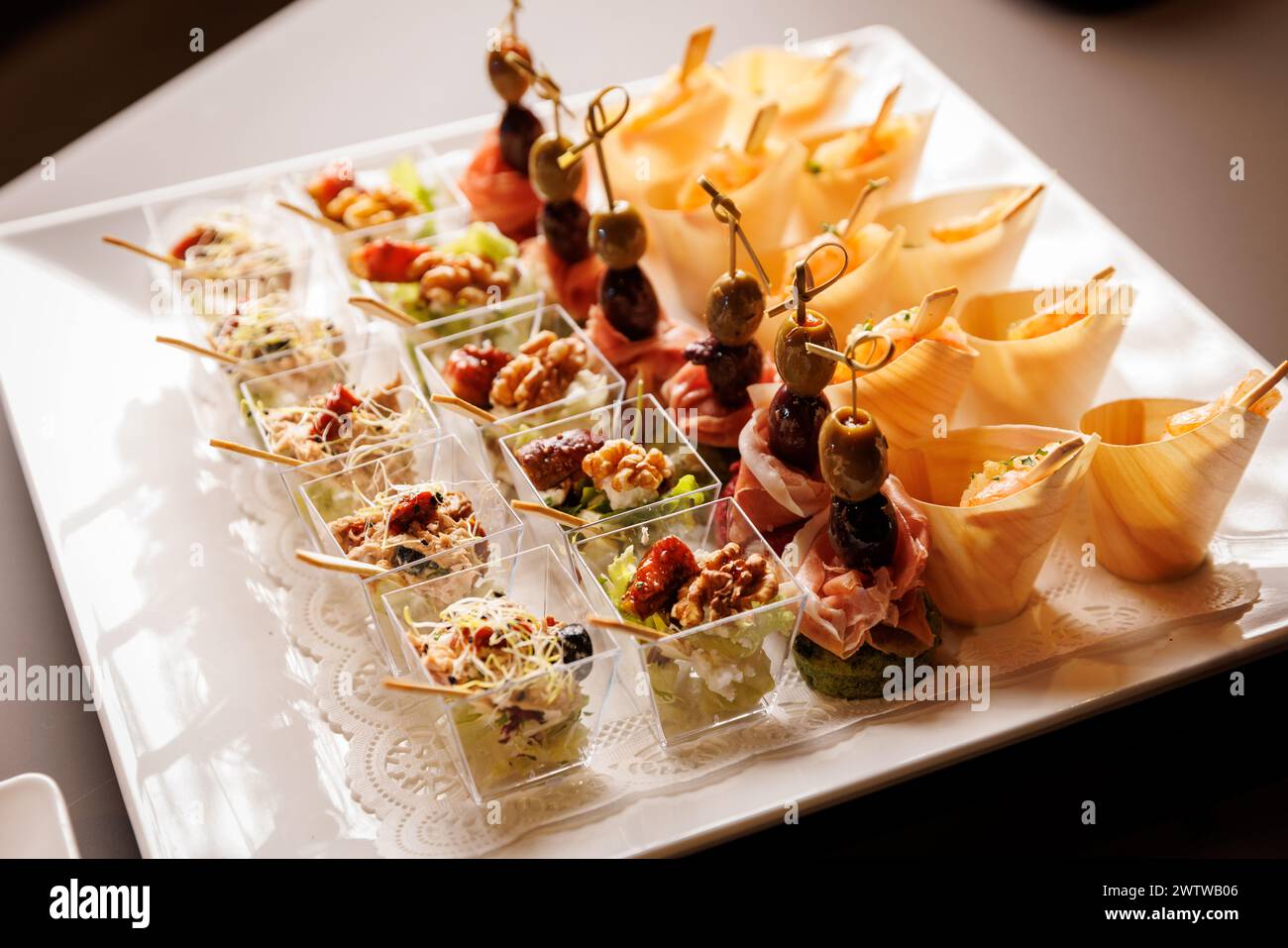 An elegant display of various appetizers on a white platter Stock Photo ...