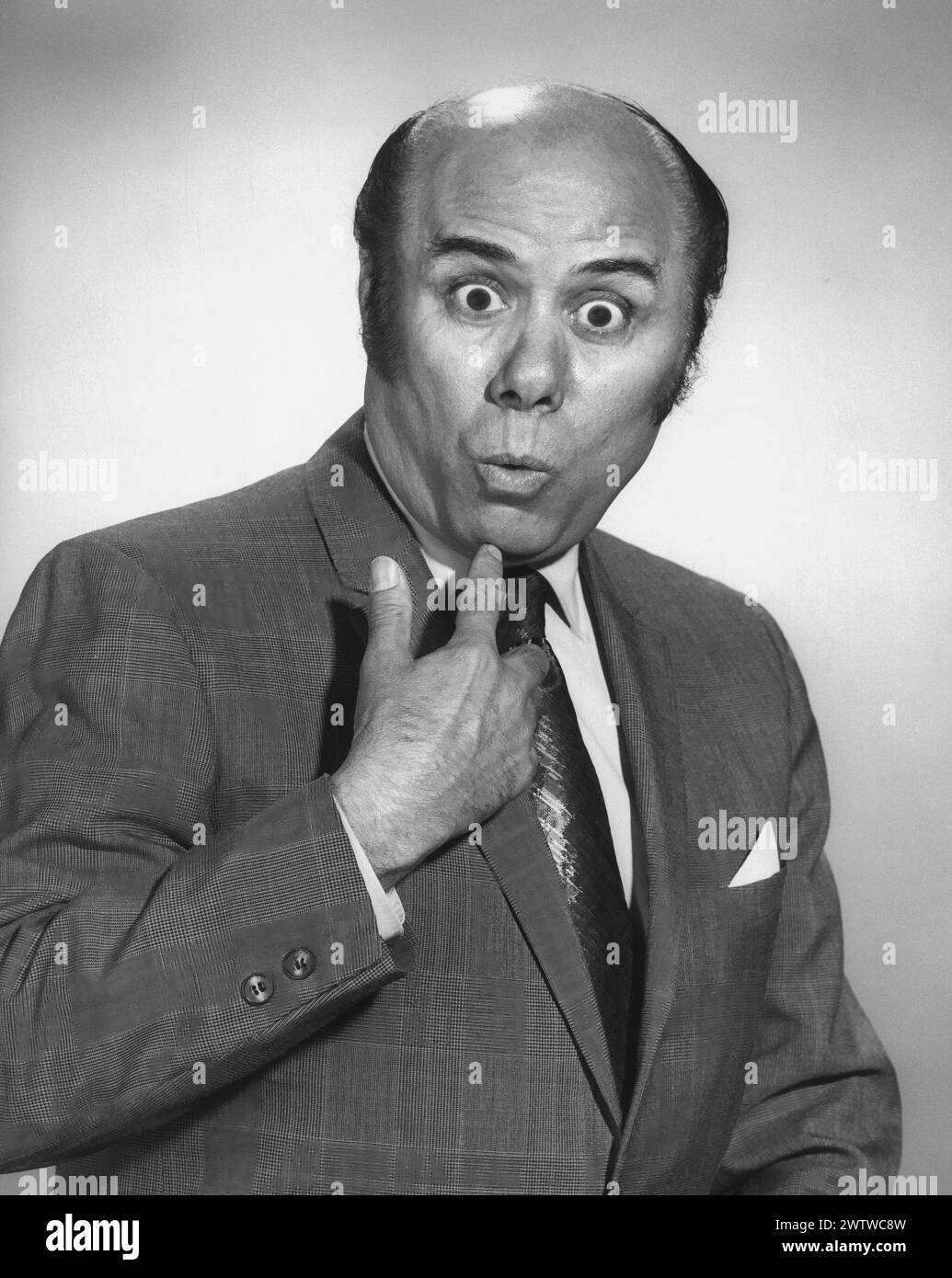 Middle-aged bald man with hair on the sides and sideburns dressed in a ...