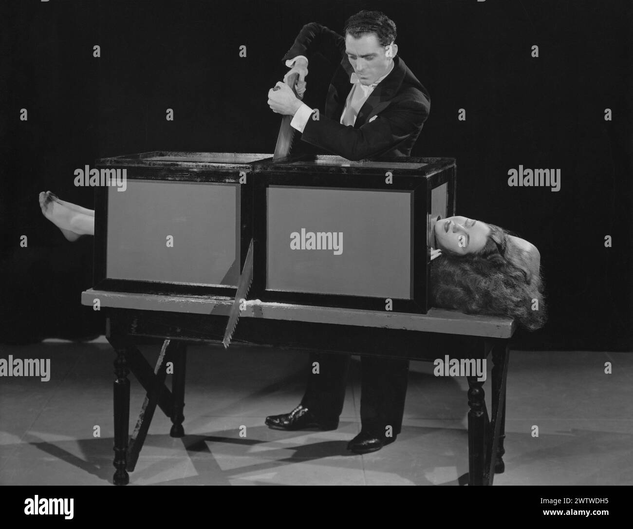 Male magician performing on stage with a woman inside of a box on the ...