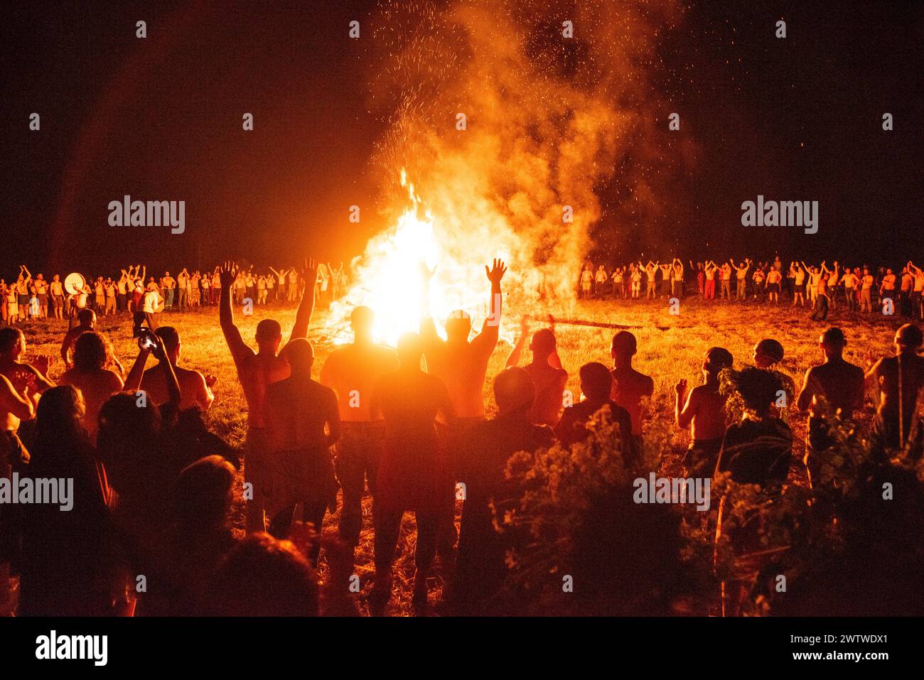 Kupala solstice celebration, lots of fire and hands up with fire glow ...