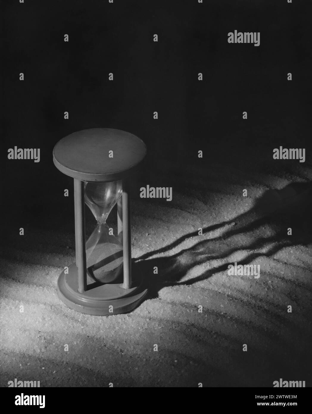 Dramatic image of a timer on a sandy background, the sands appear to ...