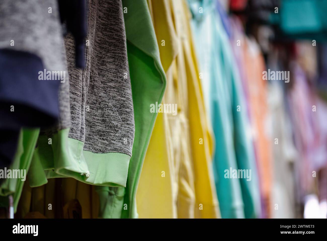 An array of various colored clothes displayed for sale in an outdoor ...