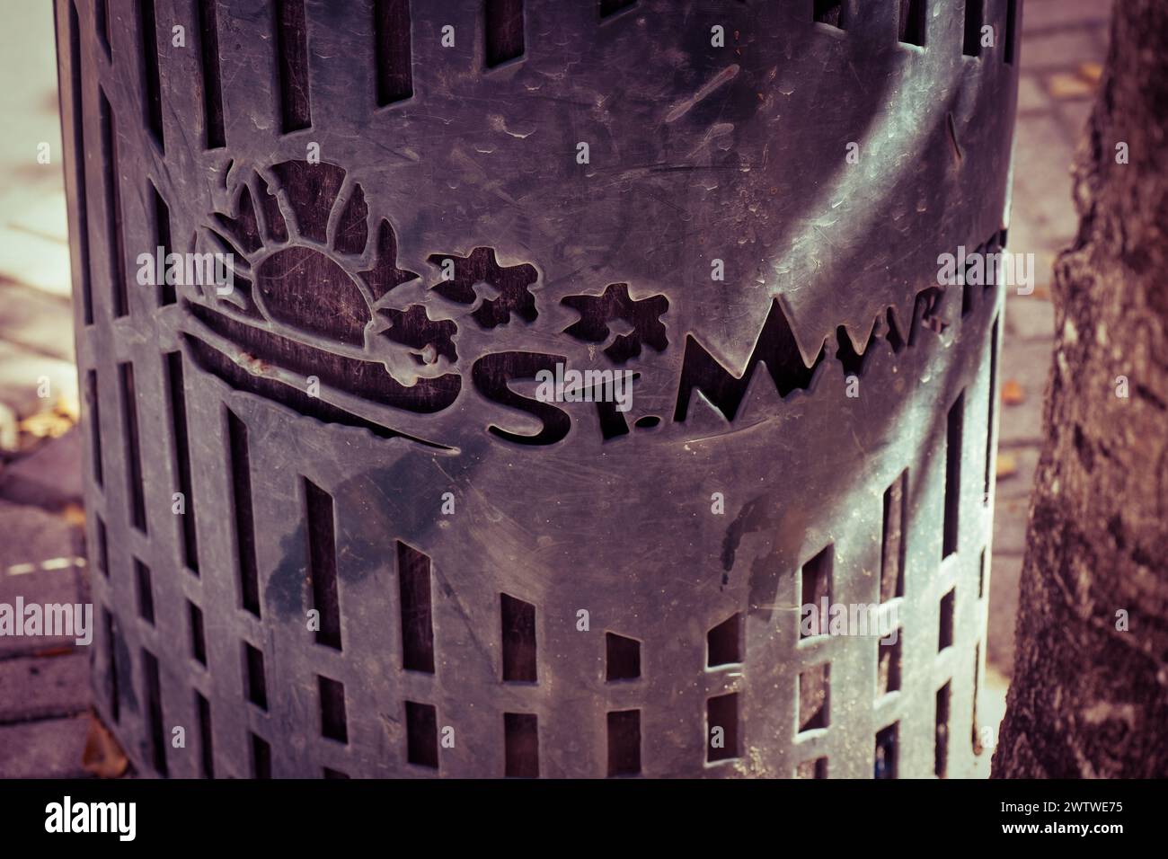 Close-up view of a unique metal trash bin on the street with artistic ...