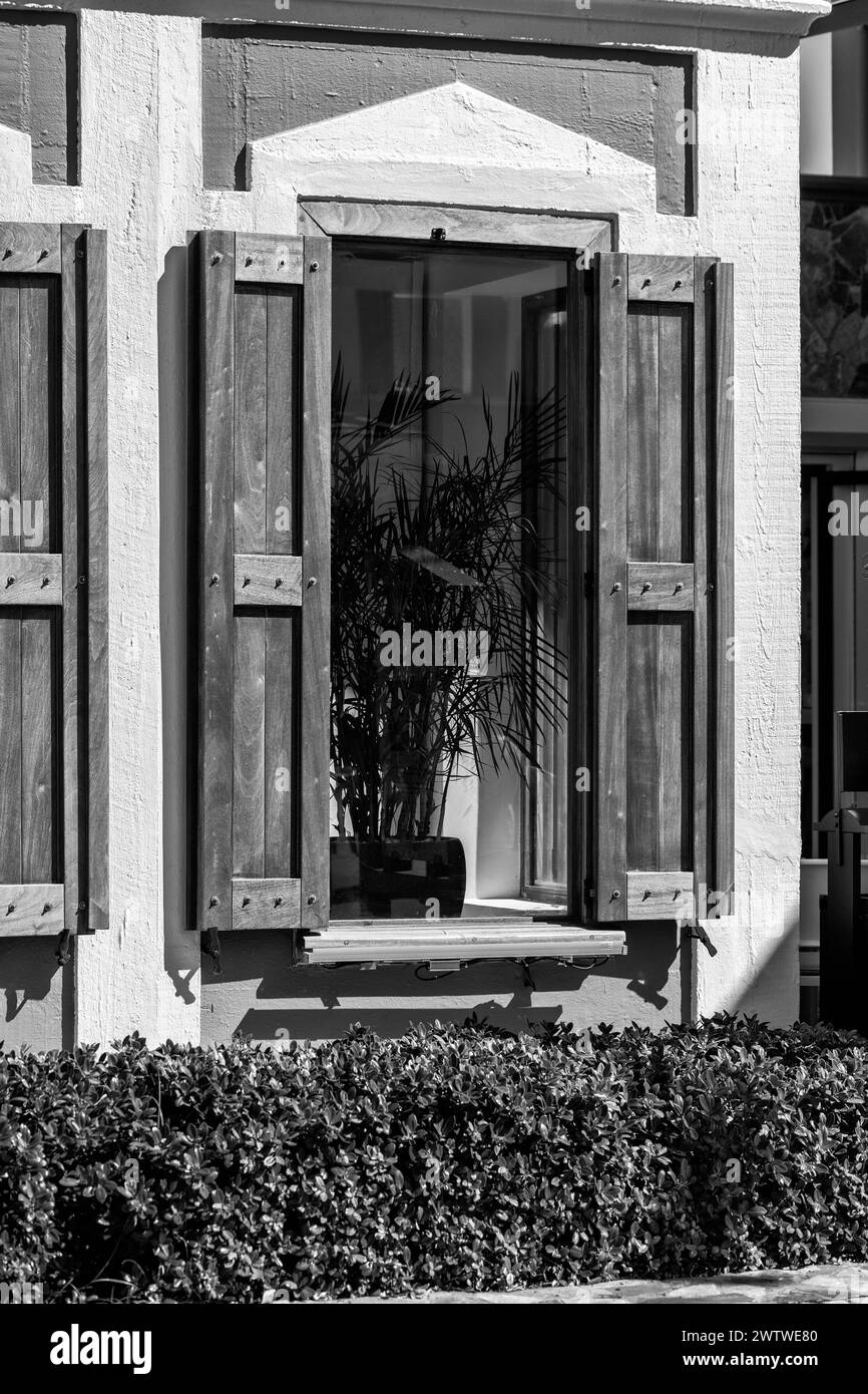 Vintage style window with closed shutters captured in a black and white ...