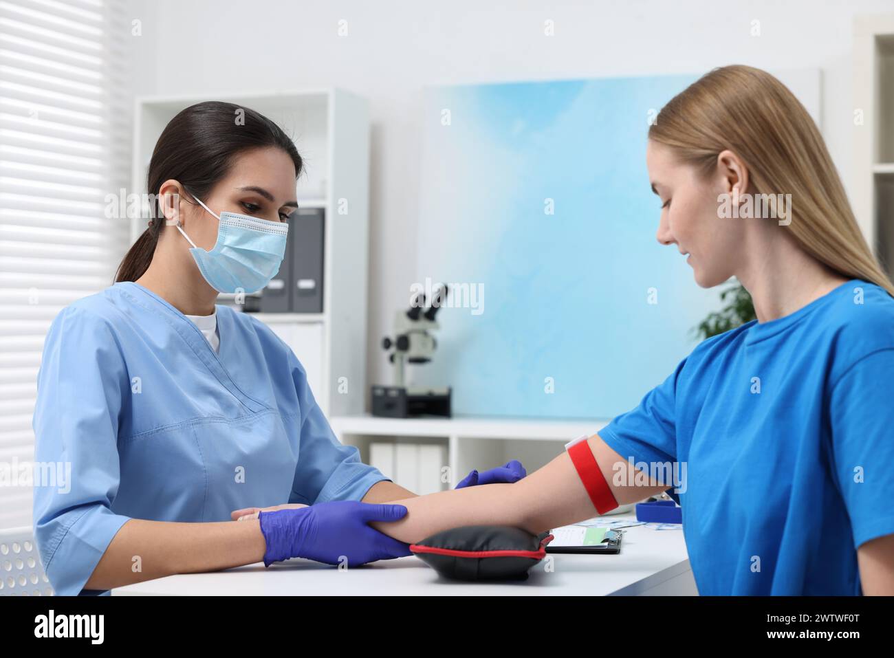 Laboratory testing. Doctor taking blood sample from patient at white ...