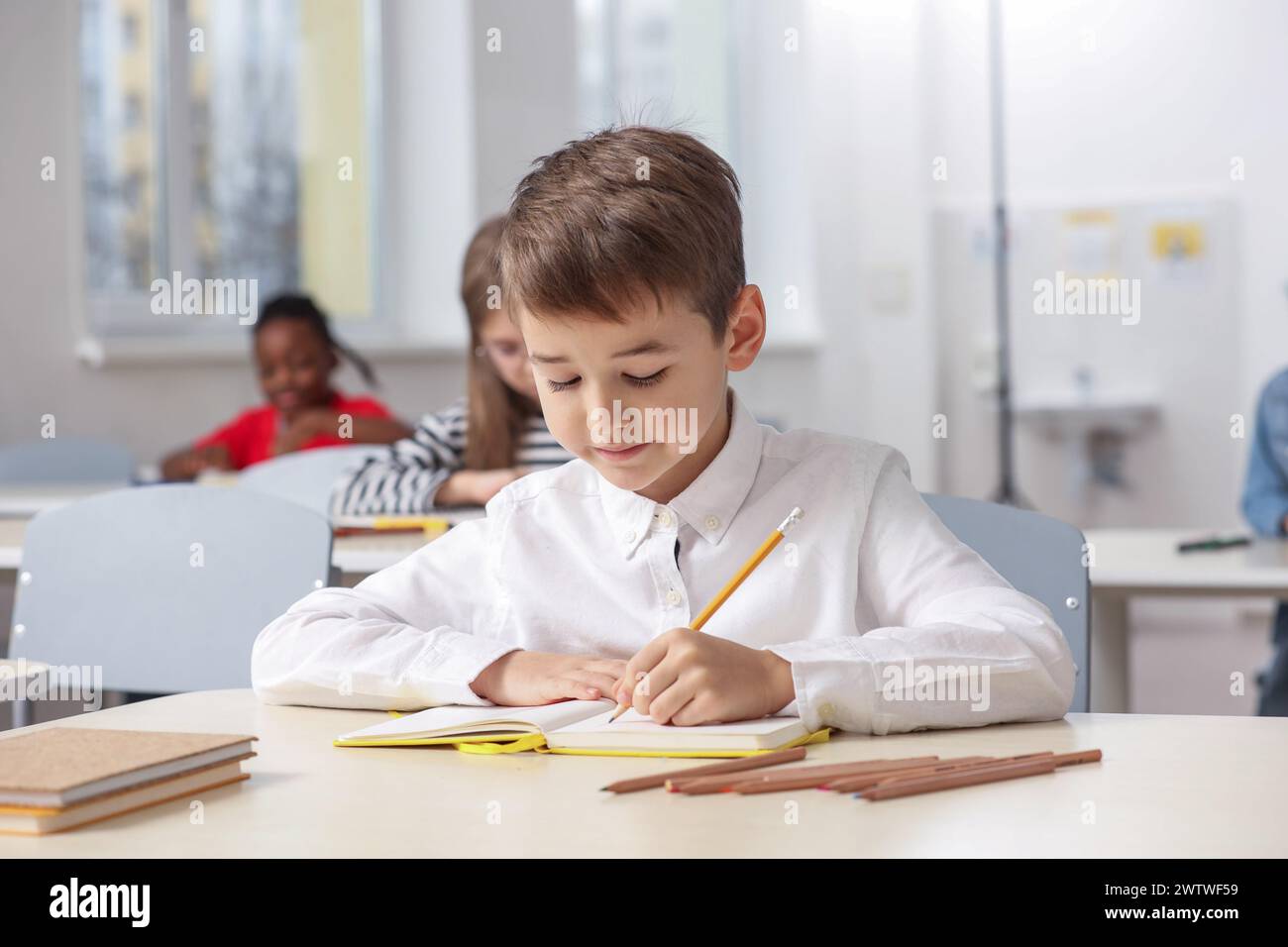 Portrait of cute little boy studying in classroom at school Stock Photo - Alamy