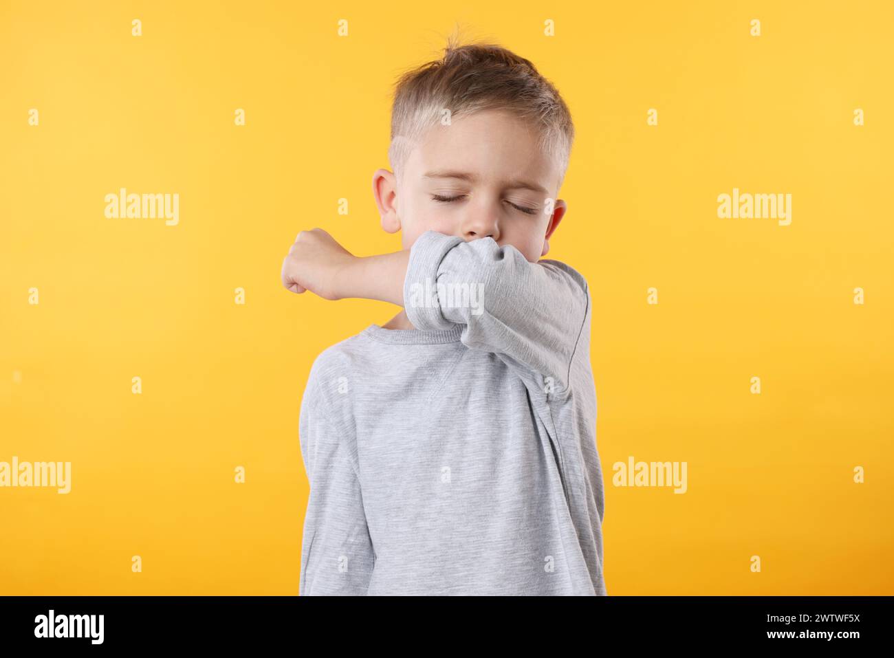 Sick boy coughing on yellow background. Cold symptoms Stock Photo - Alamy