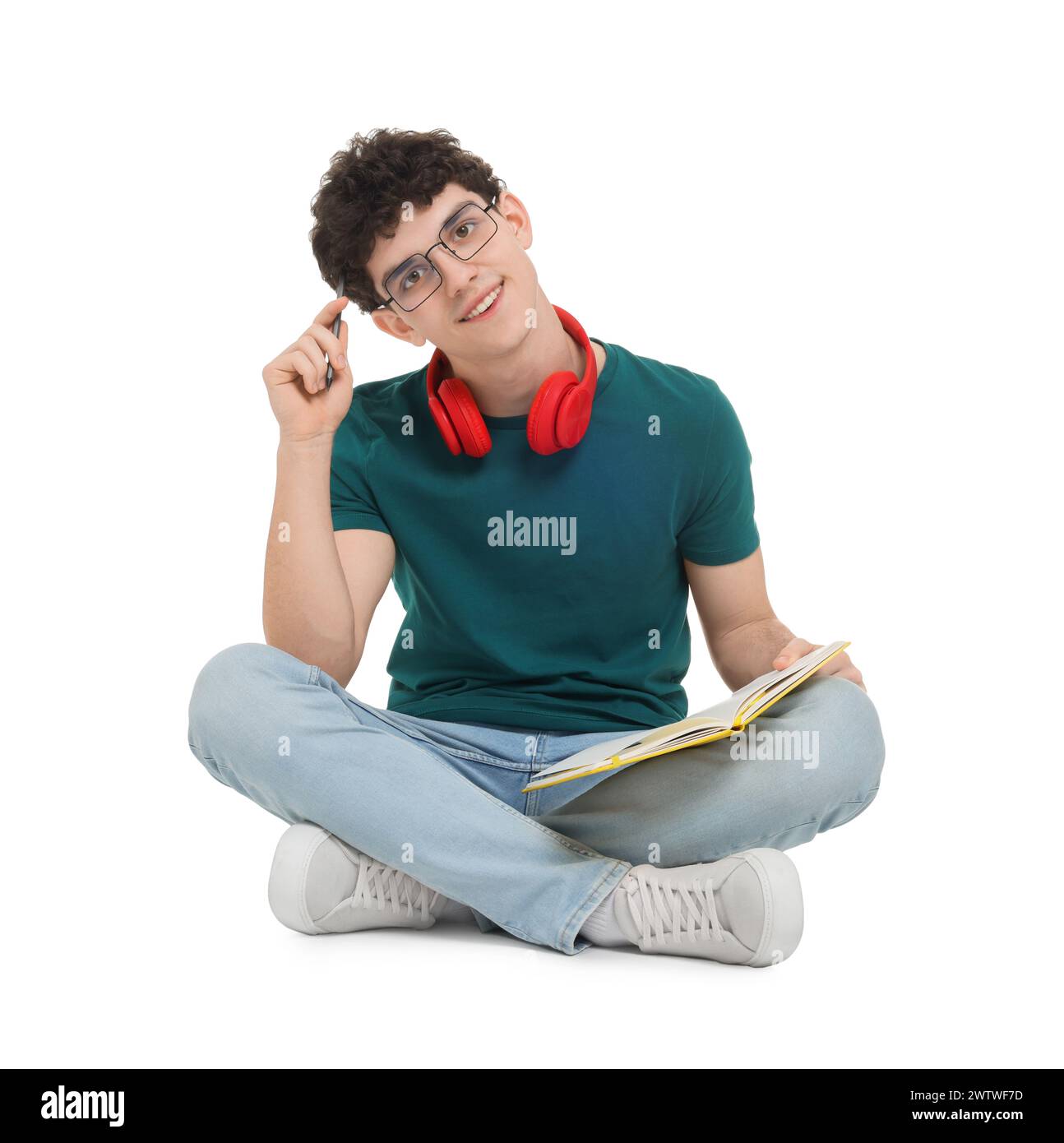 Portrait of student with notebook and headphones sitting on white ...