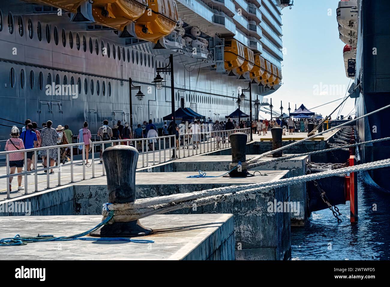 A bustling port scene featuring crowds of tourists walking near a ...