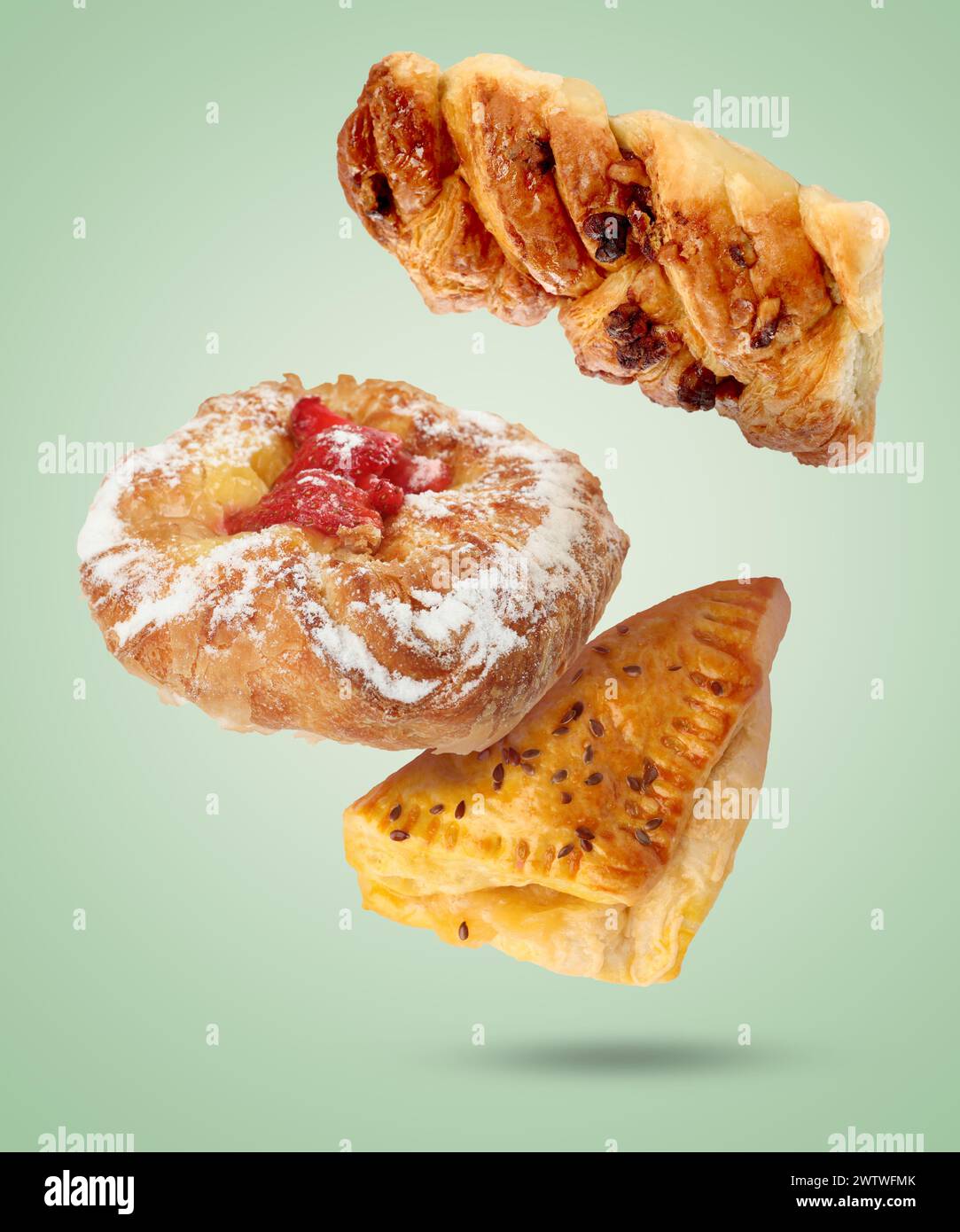 Different tasty puff pastries falling on green background Stock Photo ...