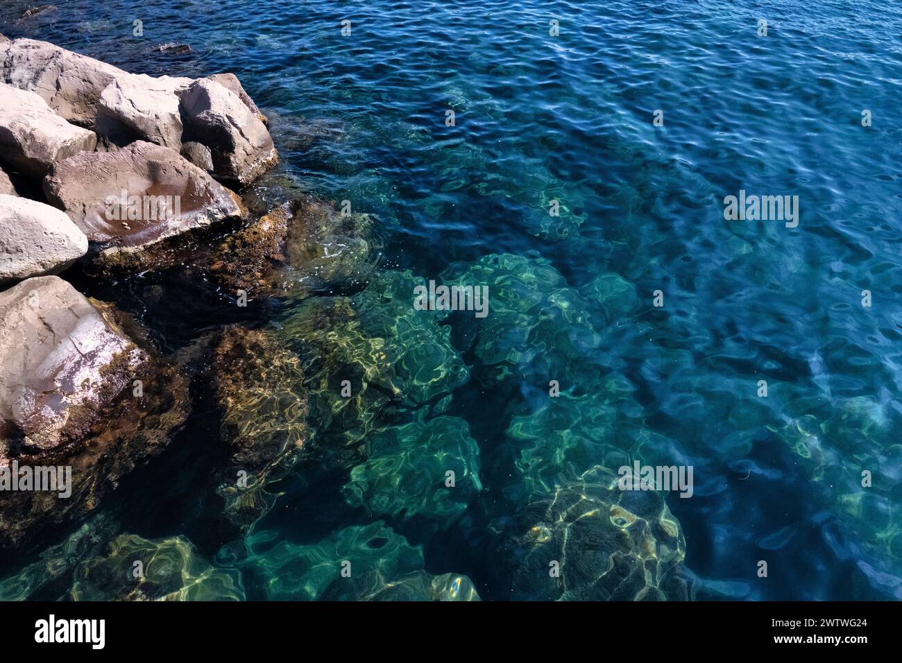 Transparent aquamarine waters reveal submerged rocks and pebbles ...