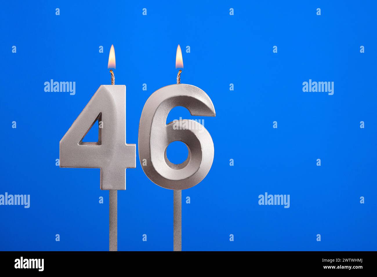 Birthday number 46 - Candle lit on blue background Stock Photo - Alamy