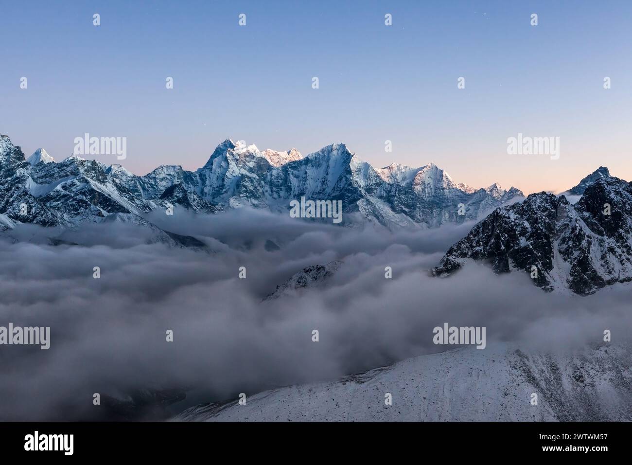 Beautiful mountain landscape in Himalayas, Nepal. High mountain peaks rising above the clouds ...