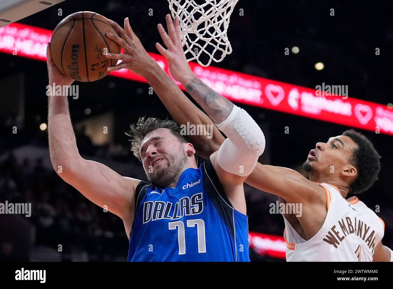 Dallas Mavericks guard Luka Doncic (77) and San Antonio Spurs center Victor Wembanyama (1) reach ...