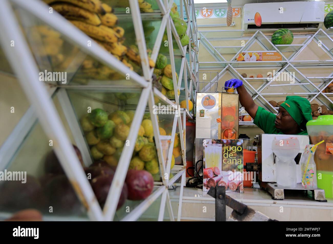 A female worker making fresh fruit juice inside a fruit juice shop on ...