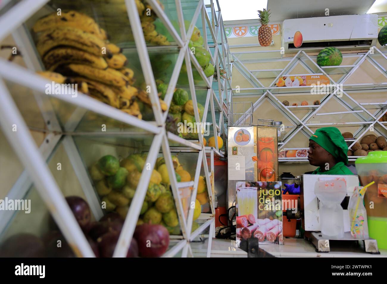 A female worker making fresh fruit juice inside a fruit juice shop on ...