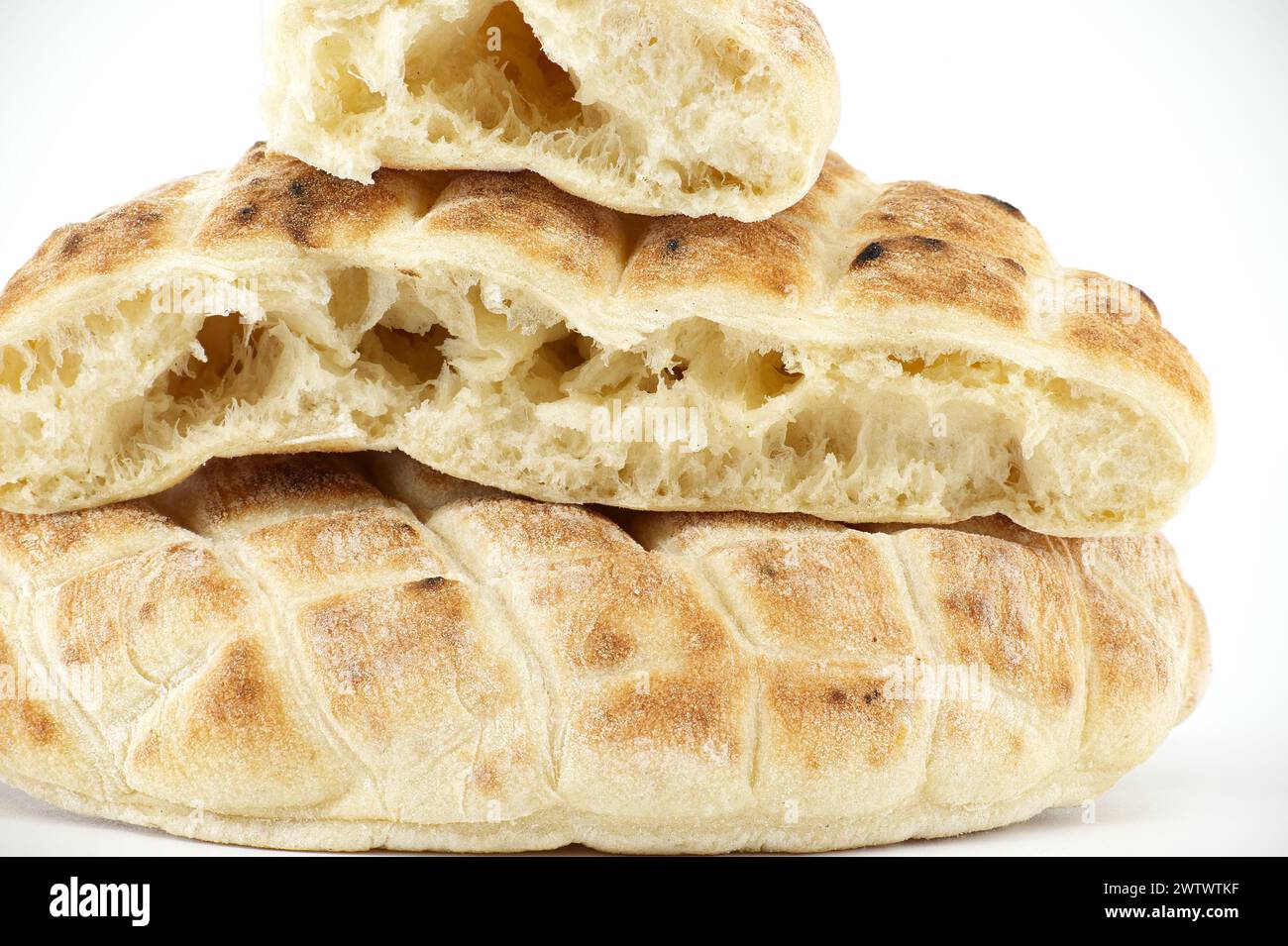 Pieces of pita flat-bread are stacked atop each other isolated on white ...