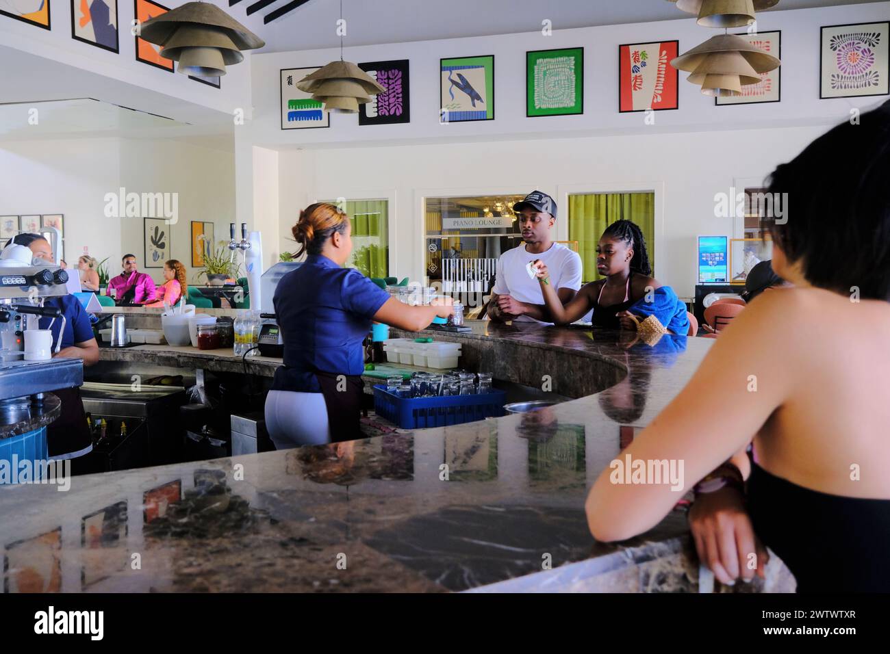 A female bartender serving drinks in the lobby bar in Ocean Blue & Sand ...